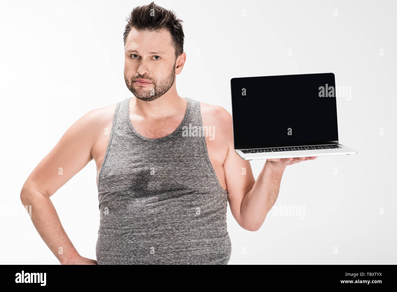 overweight man looking at camera and showing laptop with blank screen ...