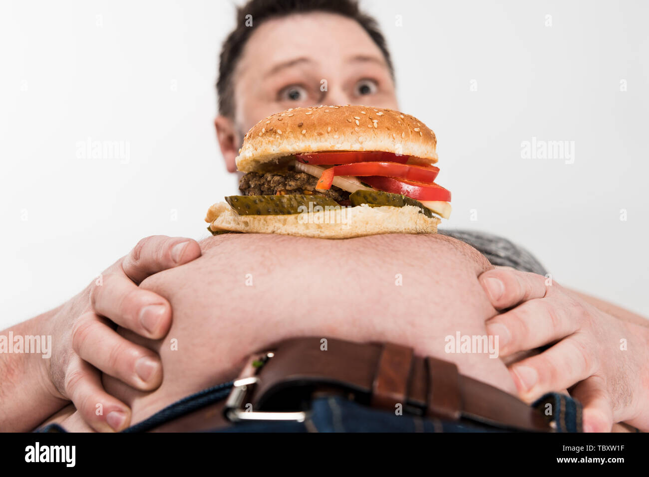 surprised overweight man with burger on belly isolated on white Stock ...