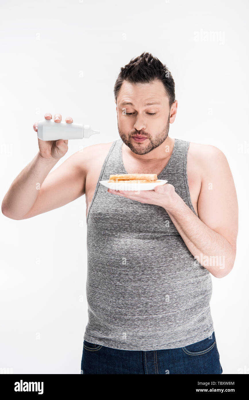 overweight man holding bottle of syrup and waffles isolated on white ...