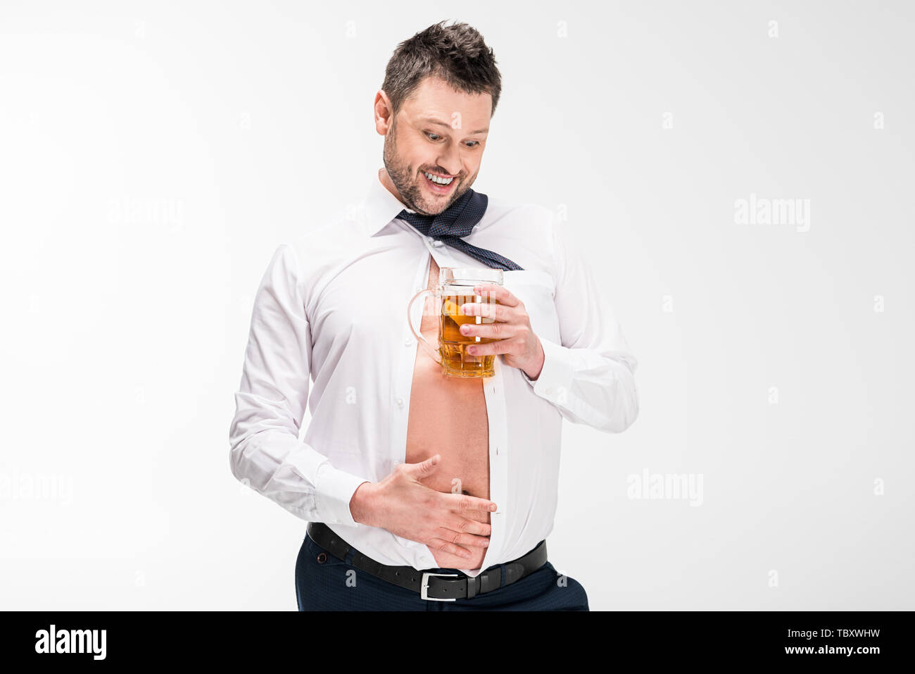 happy overweight man in tight shirt holding glass of beer and touching ...