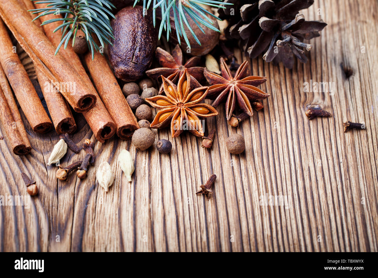 Christmas winter spices and blue pine tree branch on wooden background ...