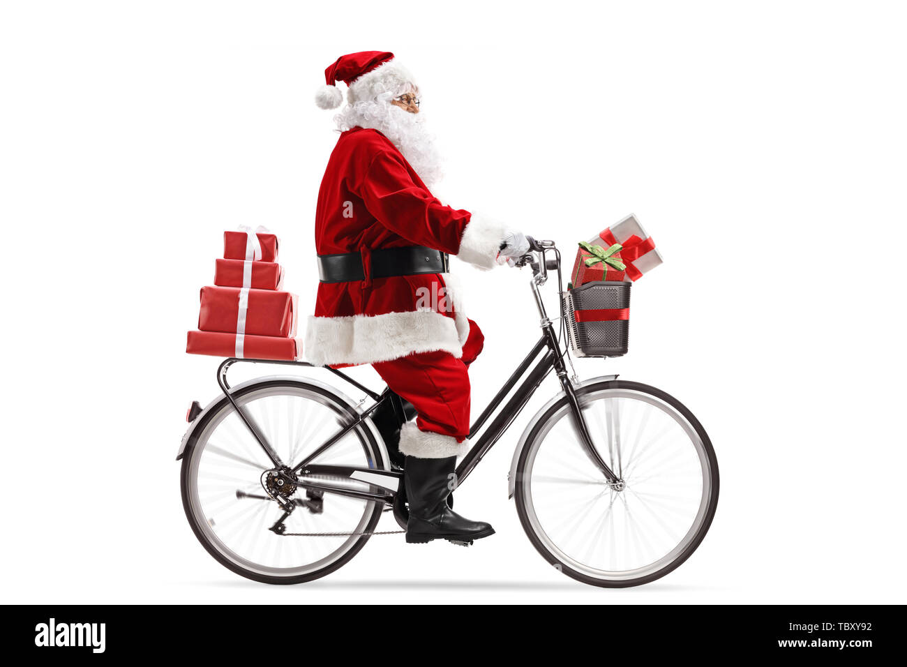 Full length profile shot of Santa Claus riding a bicycle and carrying ...