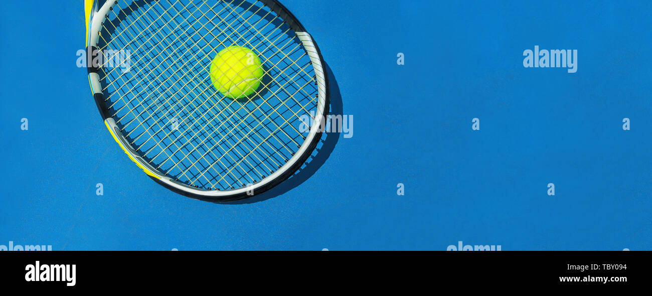 Summer sport concept with tennis ball and racket on blue hard tennis ...