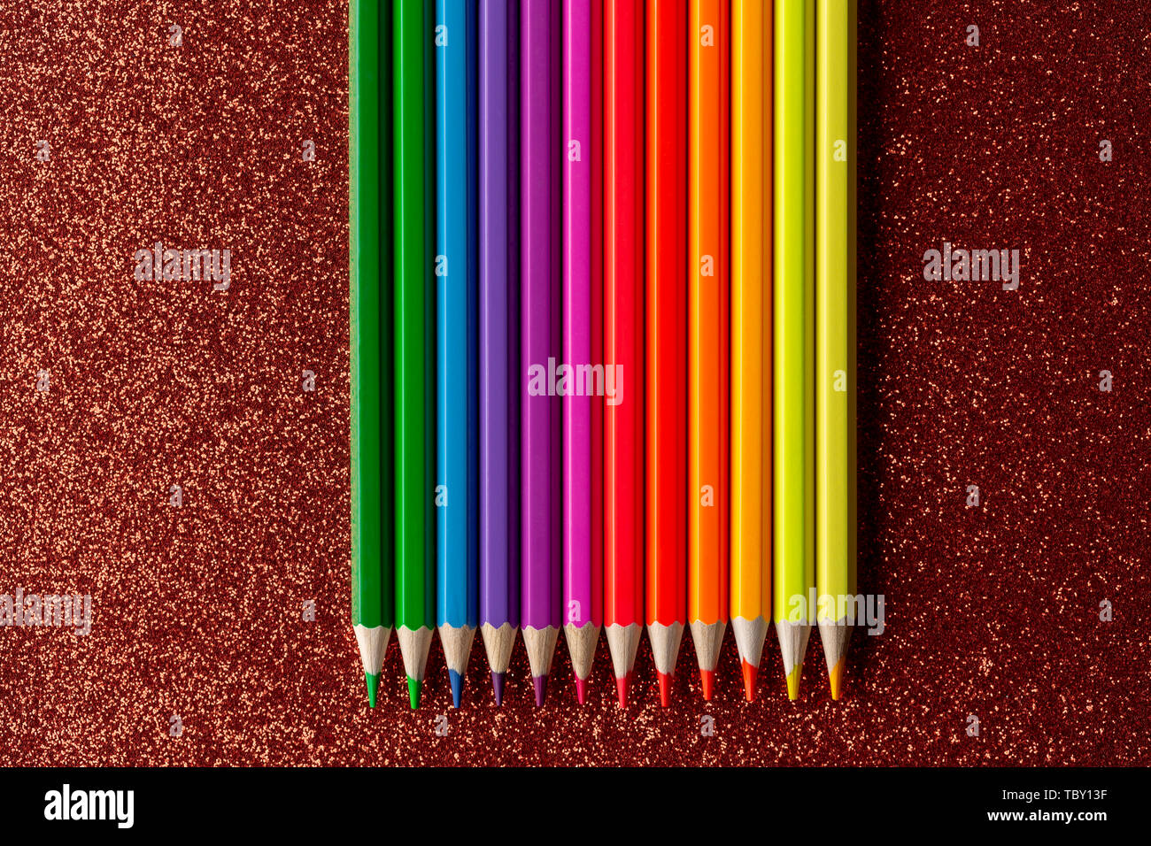Colored pencils on glitter red background Stock Photo - Alamy