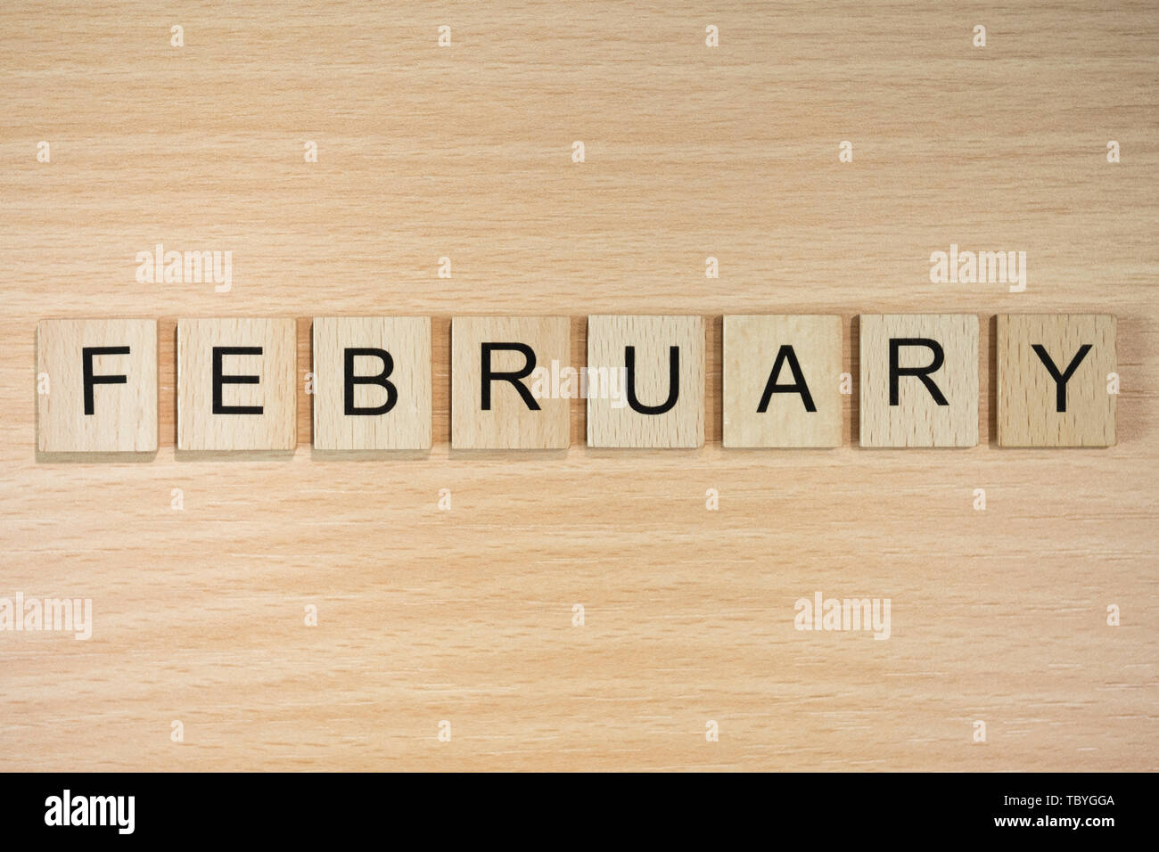 The word February, spelt out using wooden tiles on a wood effect ...