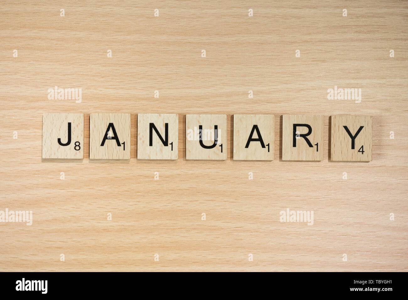 The word January, spelt out using wooden tiles on a wood effect ...