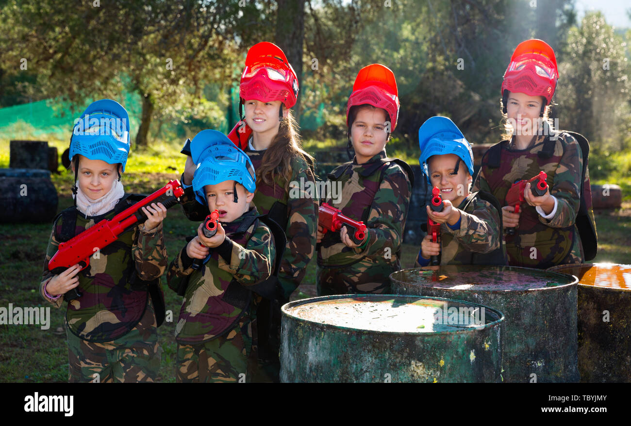 Friendly happy positive smiling group of children paintball players in ...