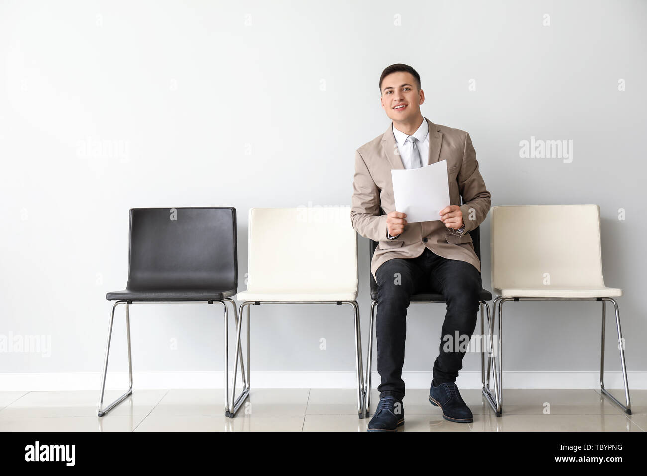 Young man waiting for job interview indoors Stock Photo - Alamy