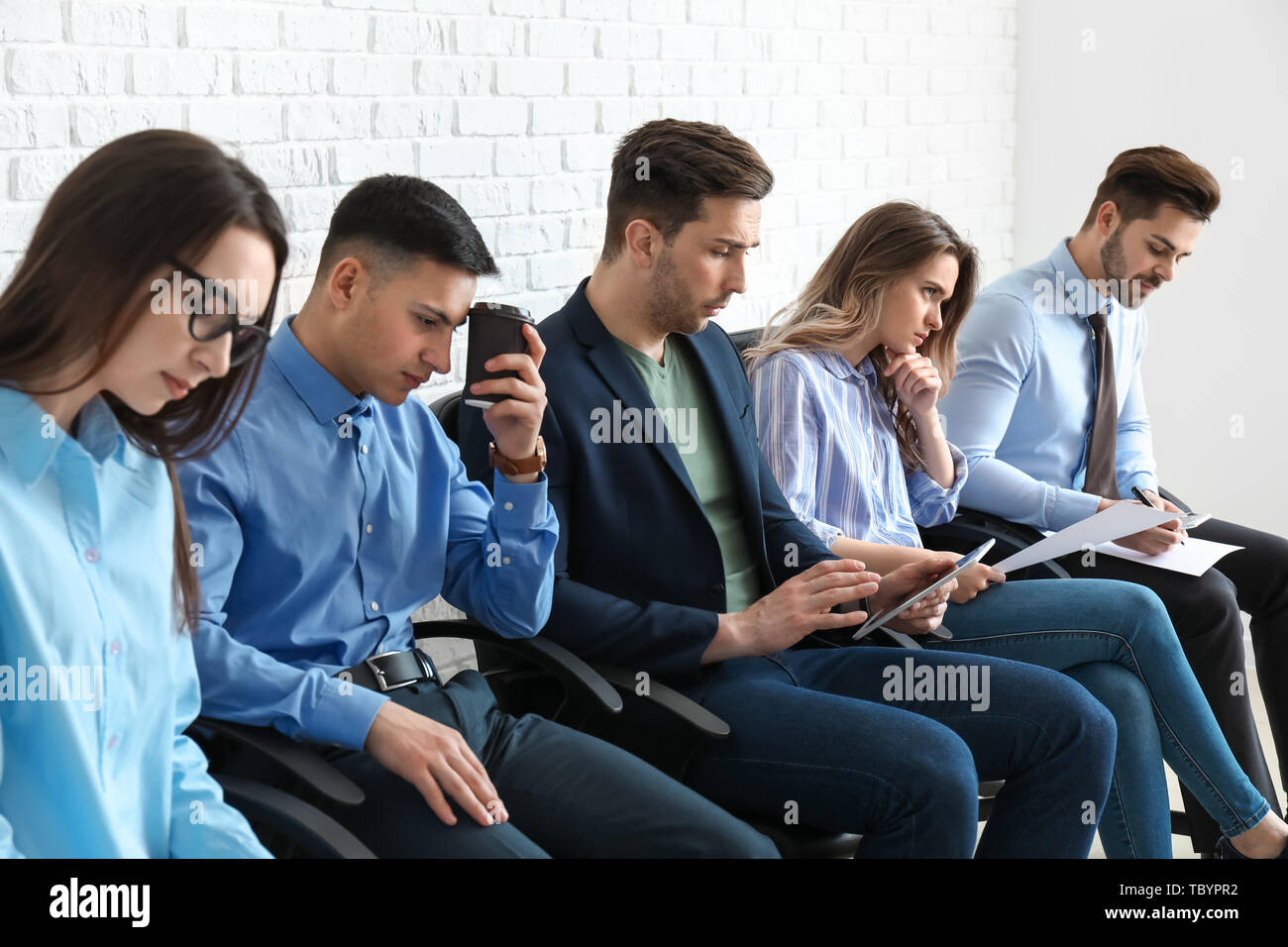 Young people waiting for job interview indoors Stock Photo - Alamy