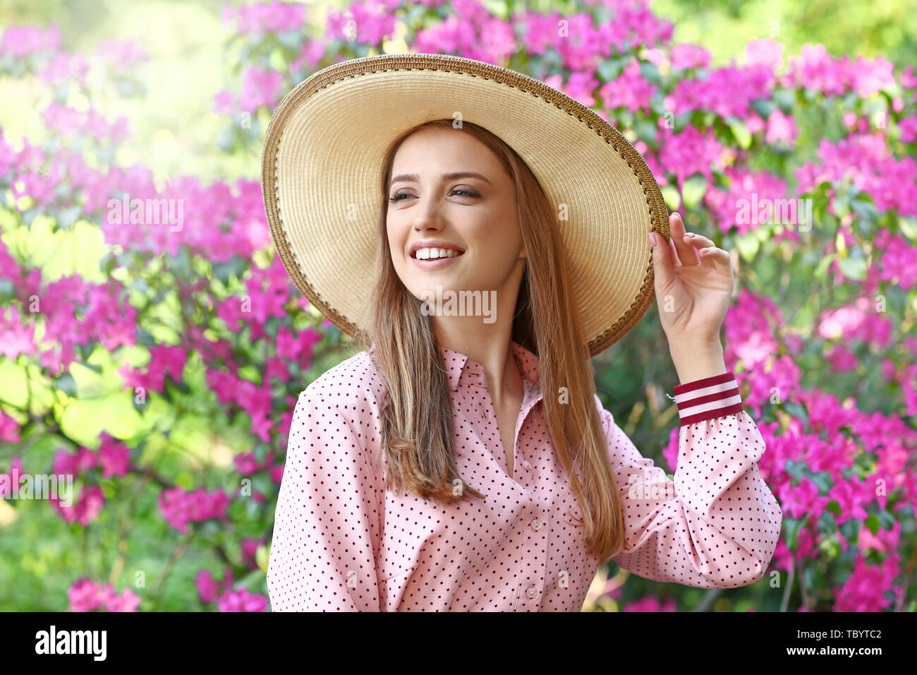 Portrait of beautiful young woman near blooming bush outdoors Stock ...