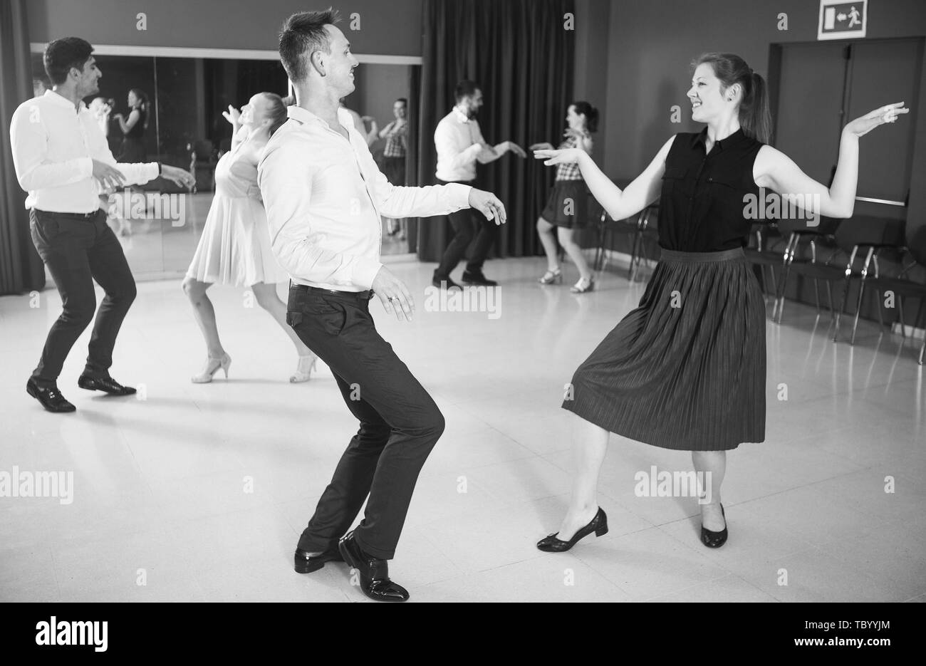 Adult dancing couples enjoying active dance in modern studio Stock ...