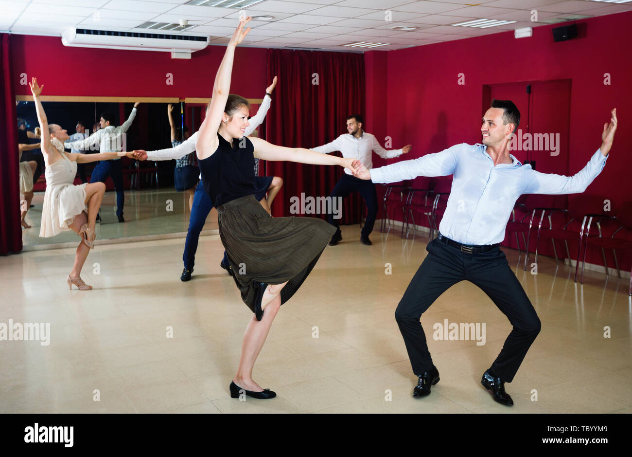 Young happy cheerful positive people dancing rock-and-roll in pairs Stock Photo - Alamy