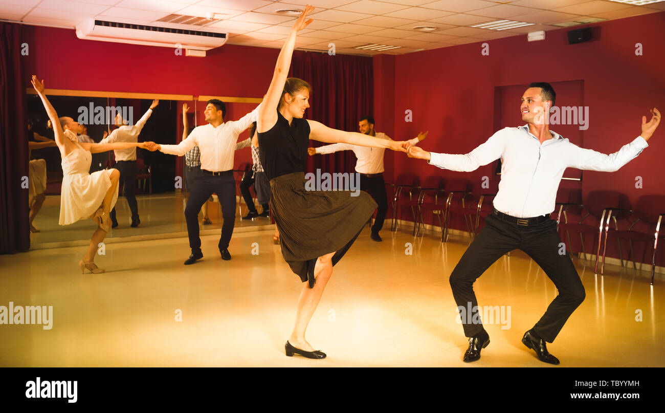 Cheerful people dancing lindy hop in pairs in dance hall Stock Photo ...
