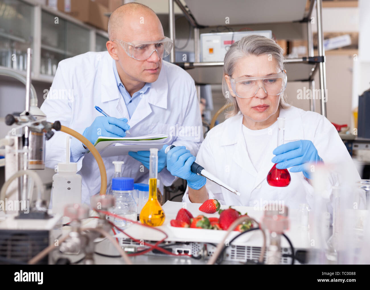 Two professional genetic scientists working in laboratory, taking notes ...