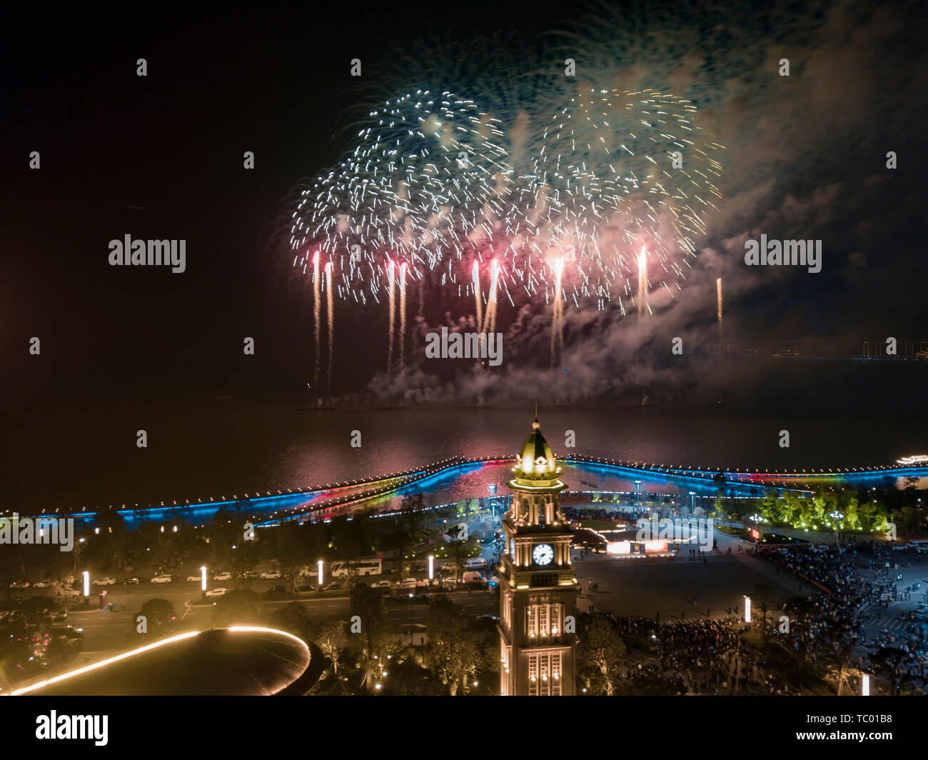 Night view of fireworks under tower landmark, blooming at sea, colorful ...