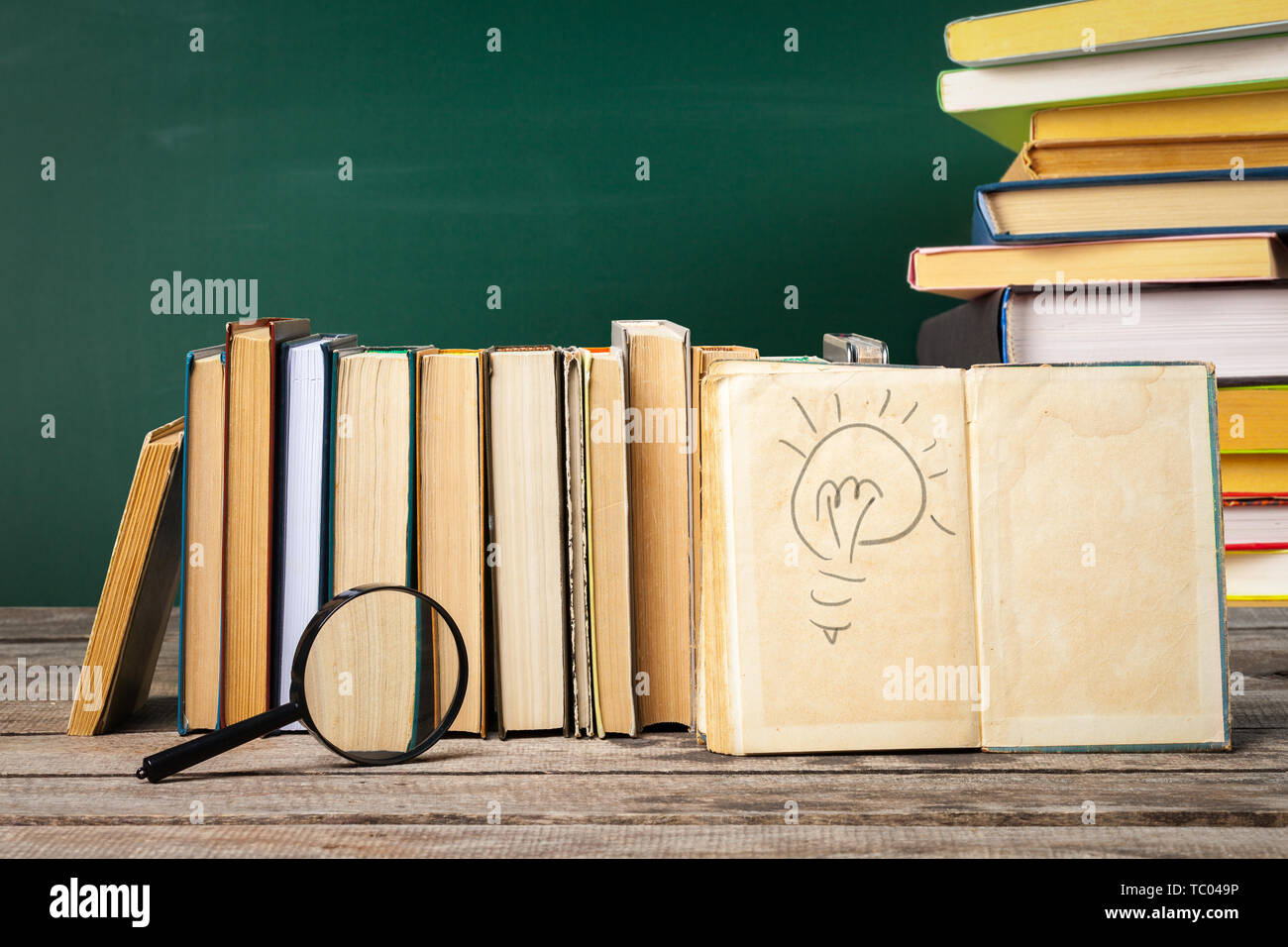 School blackboard with pile of books Stock Photo - Alamy