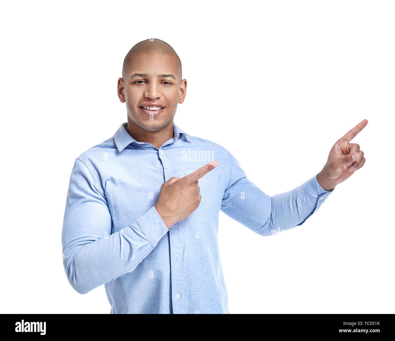 Handsome African-American man pointing at something on white background ...