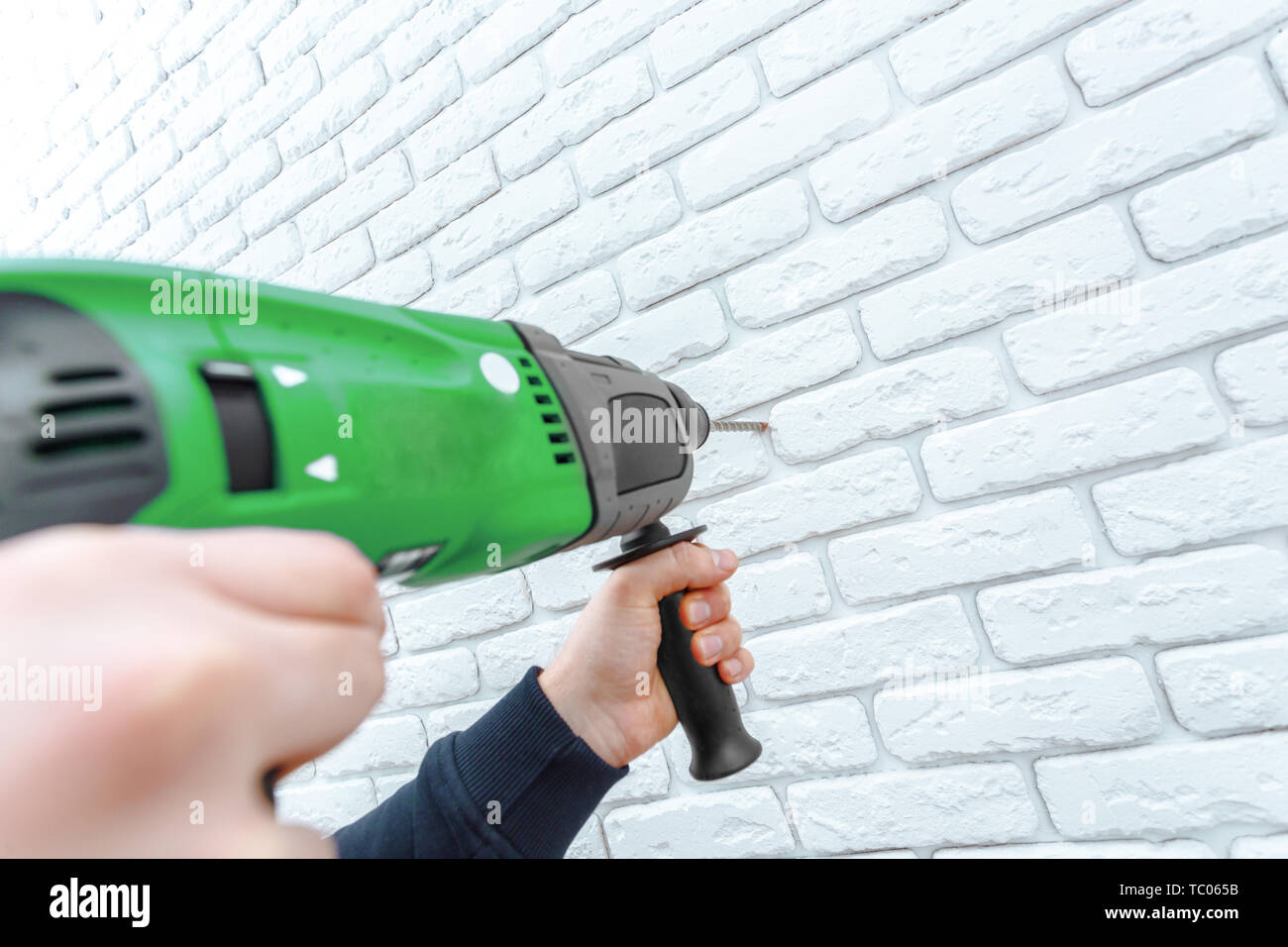 Use hammer drill to drill the wall Stock Photo - Alamy