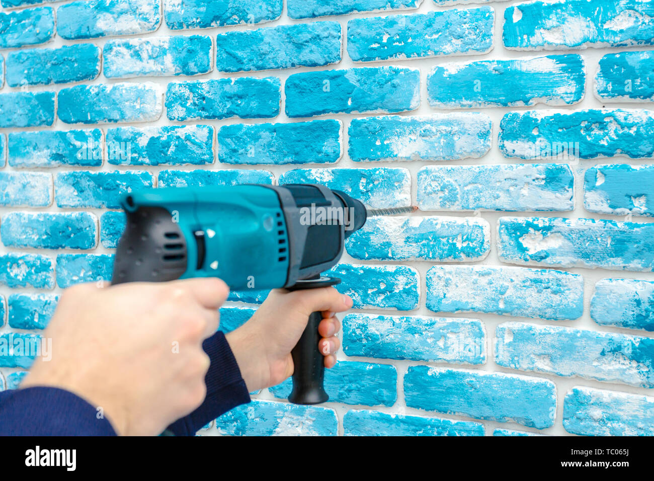 Use hammer drill to drill the wall Stock Photo - Alamy