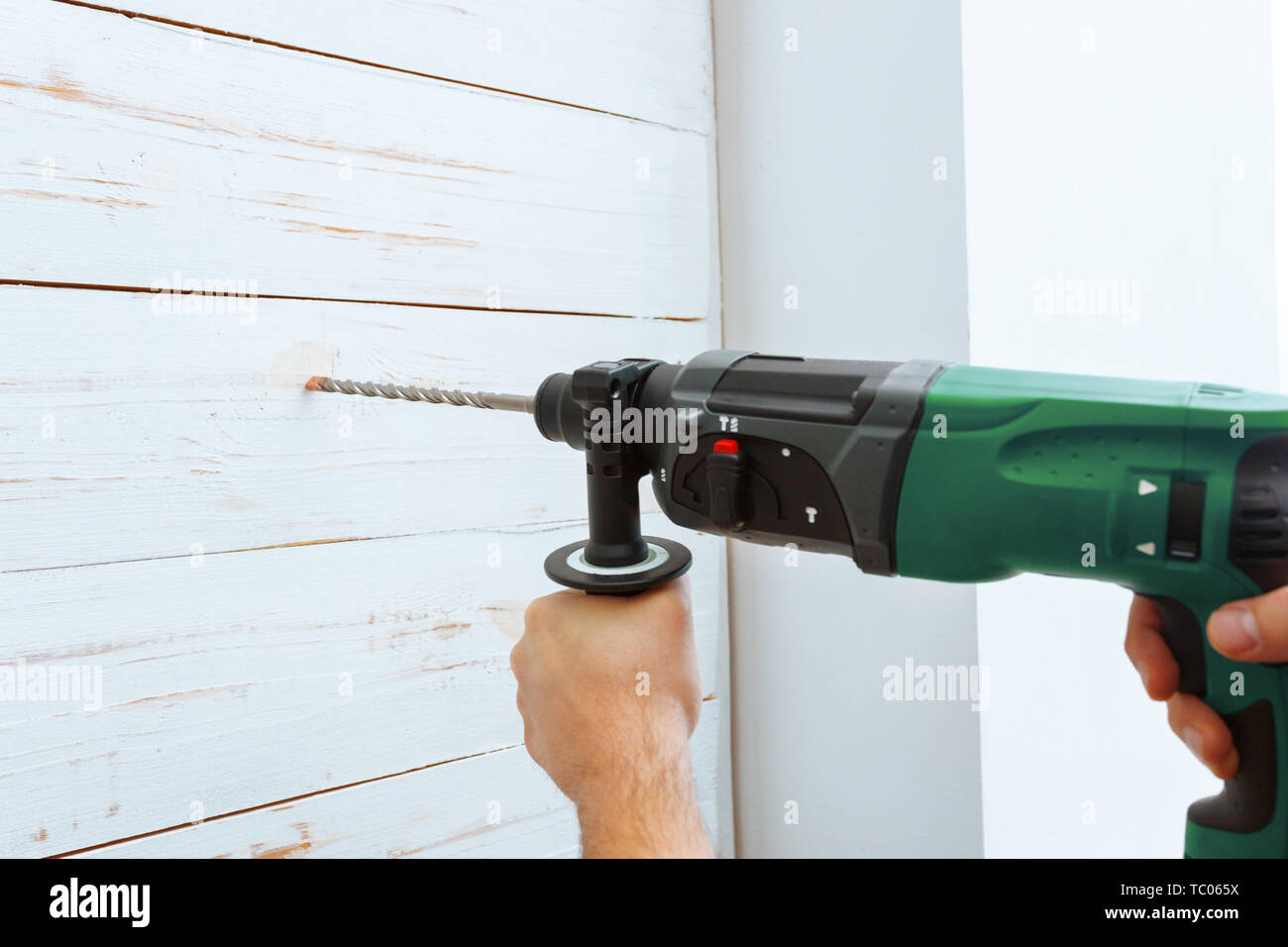 Use hammer drill to drill the wall Stock Photo - Alamy