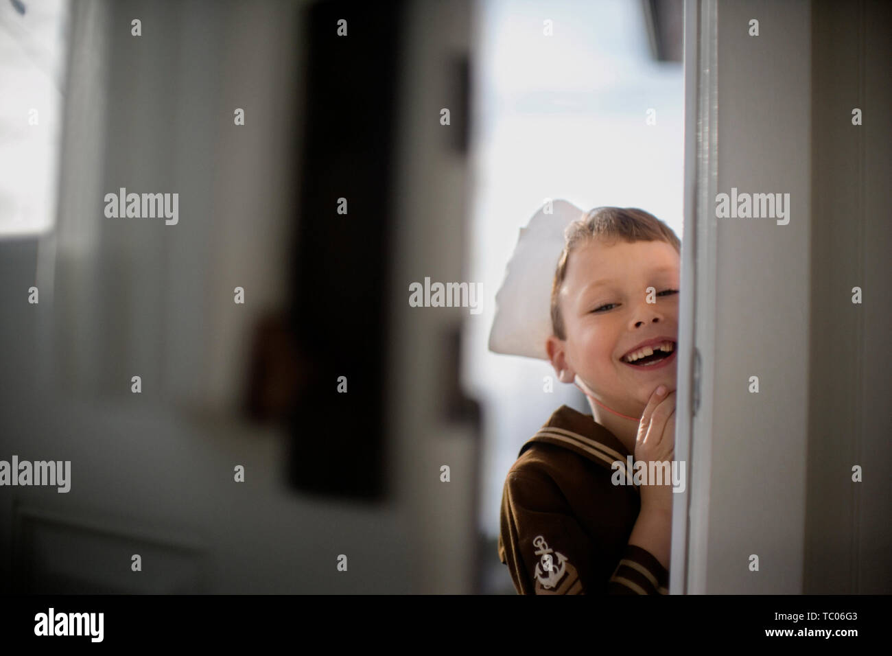 View of an adorable little boy leaning against a door Stock Photo - Alamy