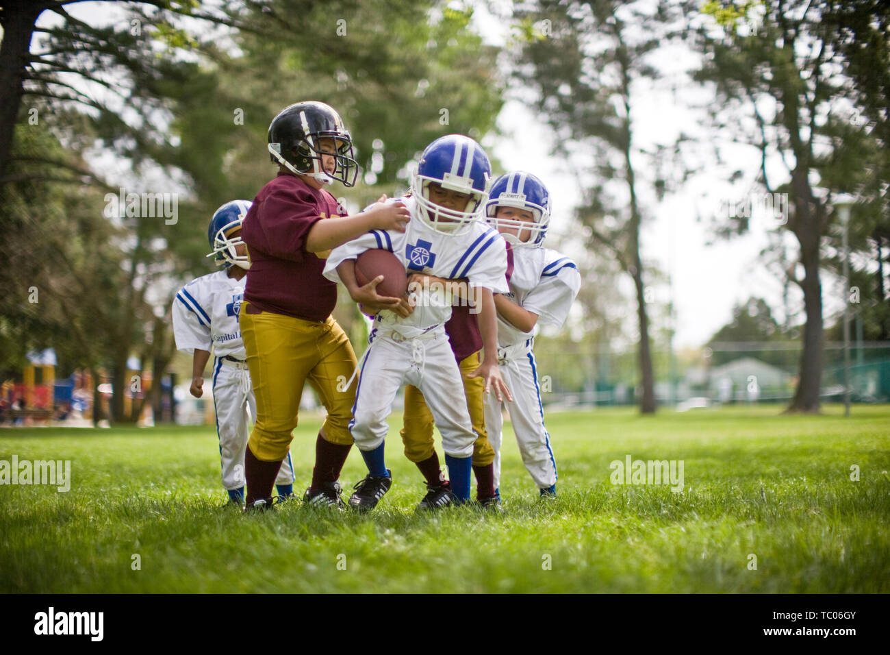 Kids Playing American Football In The Park