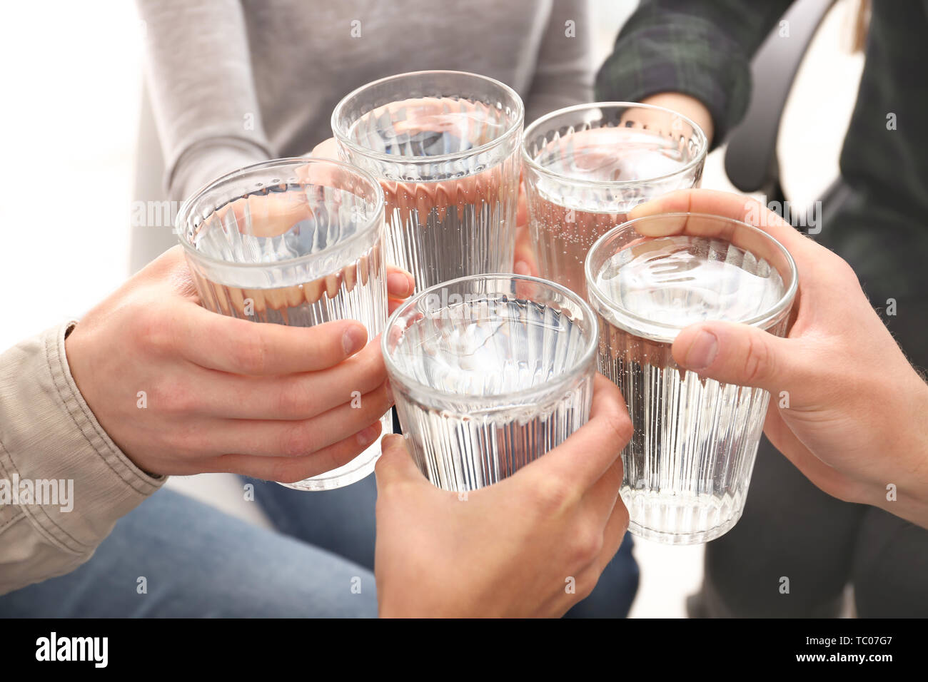 Group of people drinking water indoors, closeup Stock Photo - Alamy
