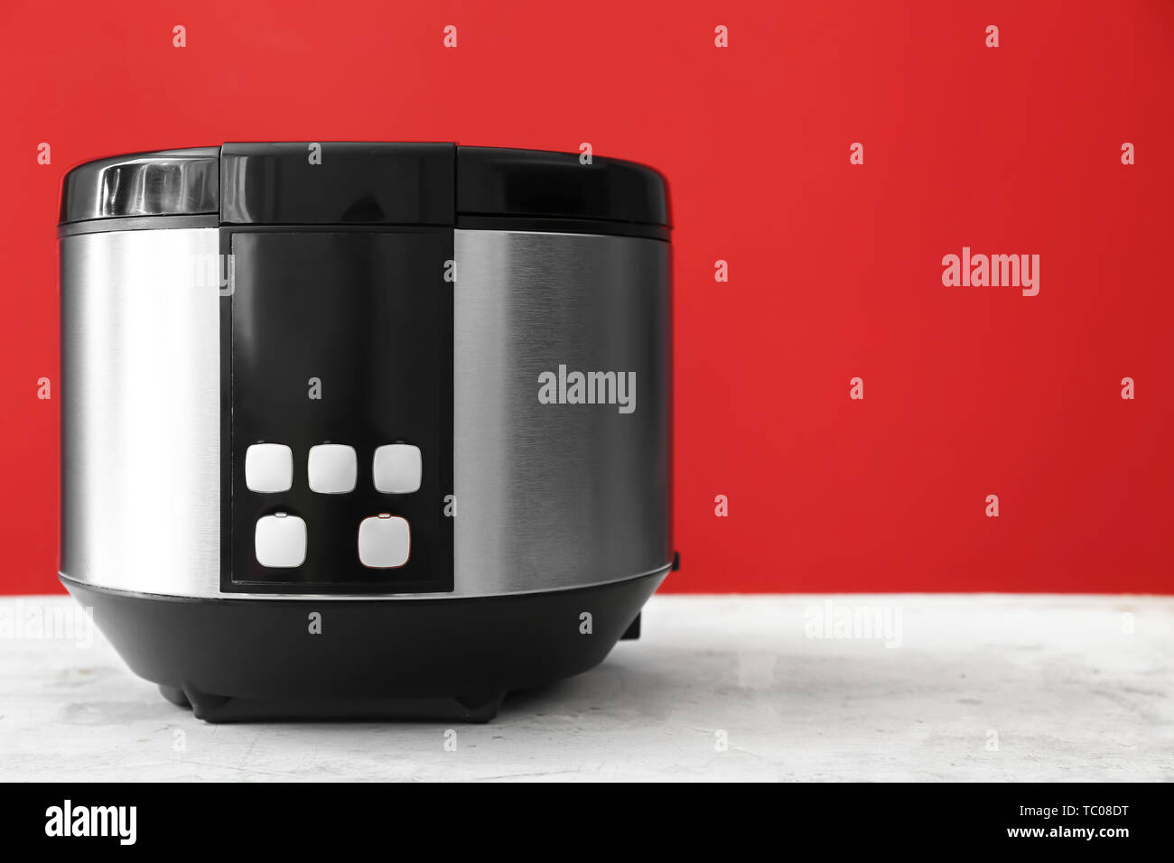 Modern multi cooker on table against color background Stock Photo - Alamy