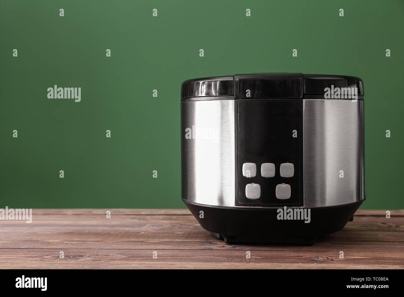 Modern multi cooker on table against color background Stock Photo - Alamy