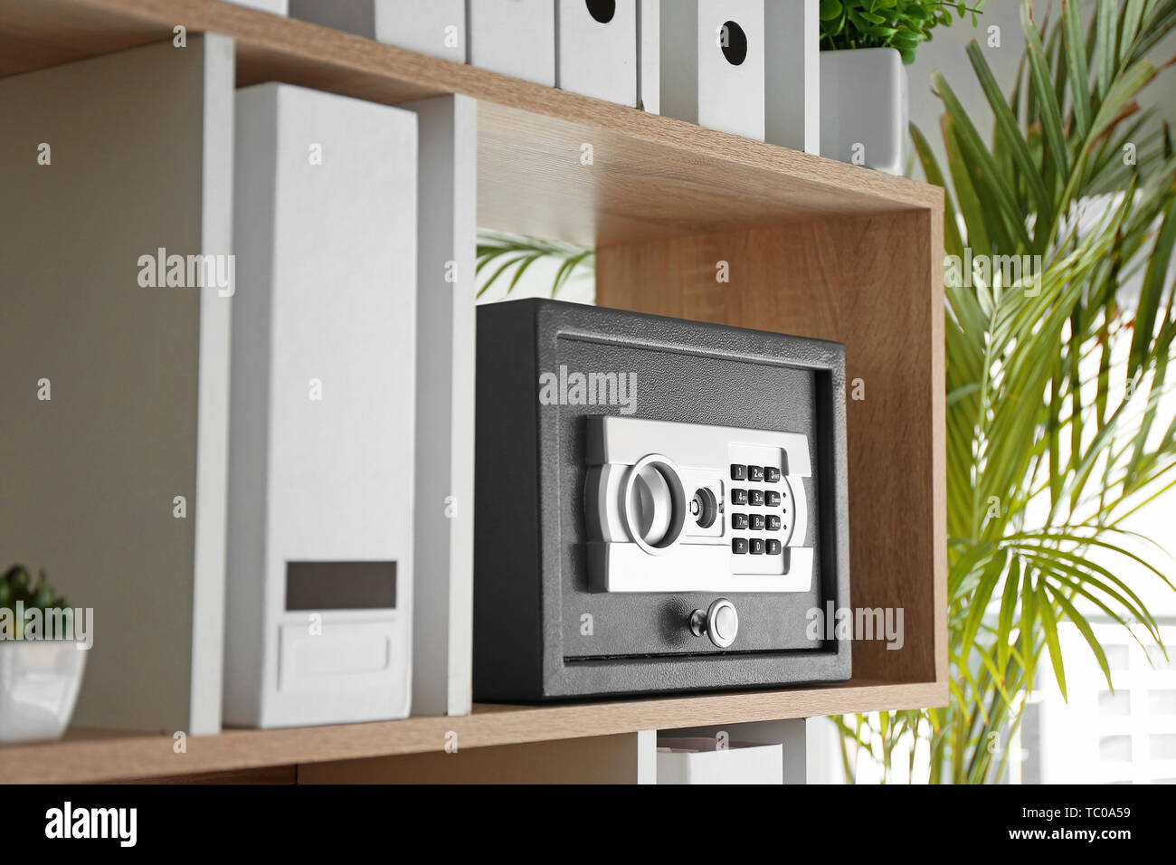 Modern safe on shelf in office Stock Photo - Alamy