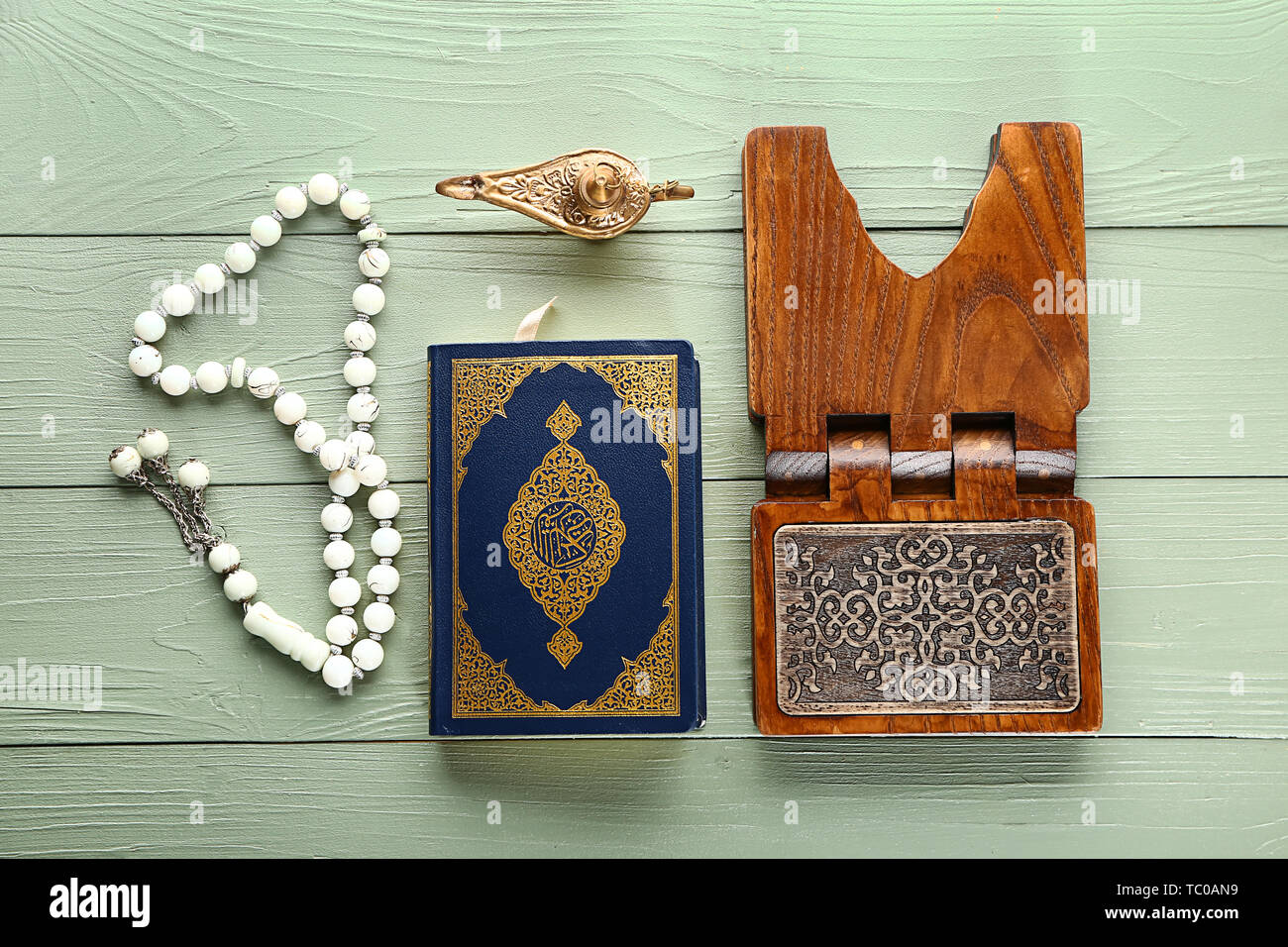 Koran, rehal, Muslim beads and lamp on wooden background Stock Photo ...
