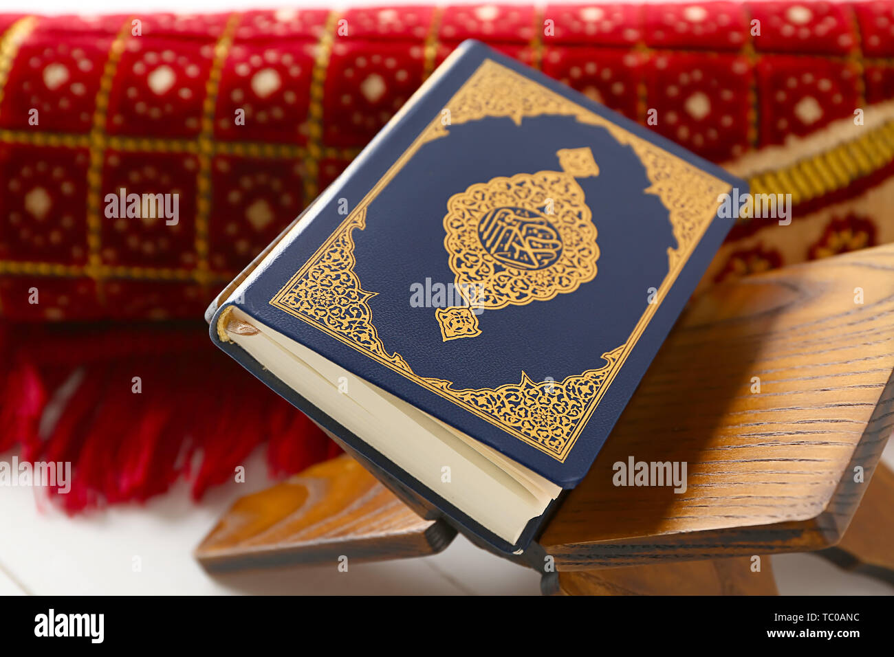 Koran, rehal and Muslim prayer mat on white background Stock Photo - Alamy