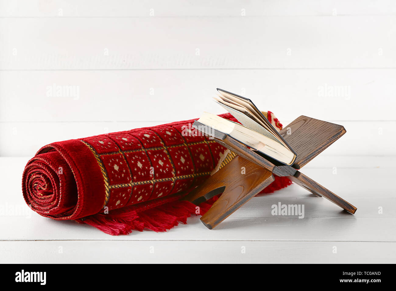 Muslim prayer mat and Koran on white wooden table Stock Photo - Alamy