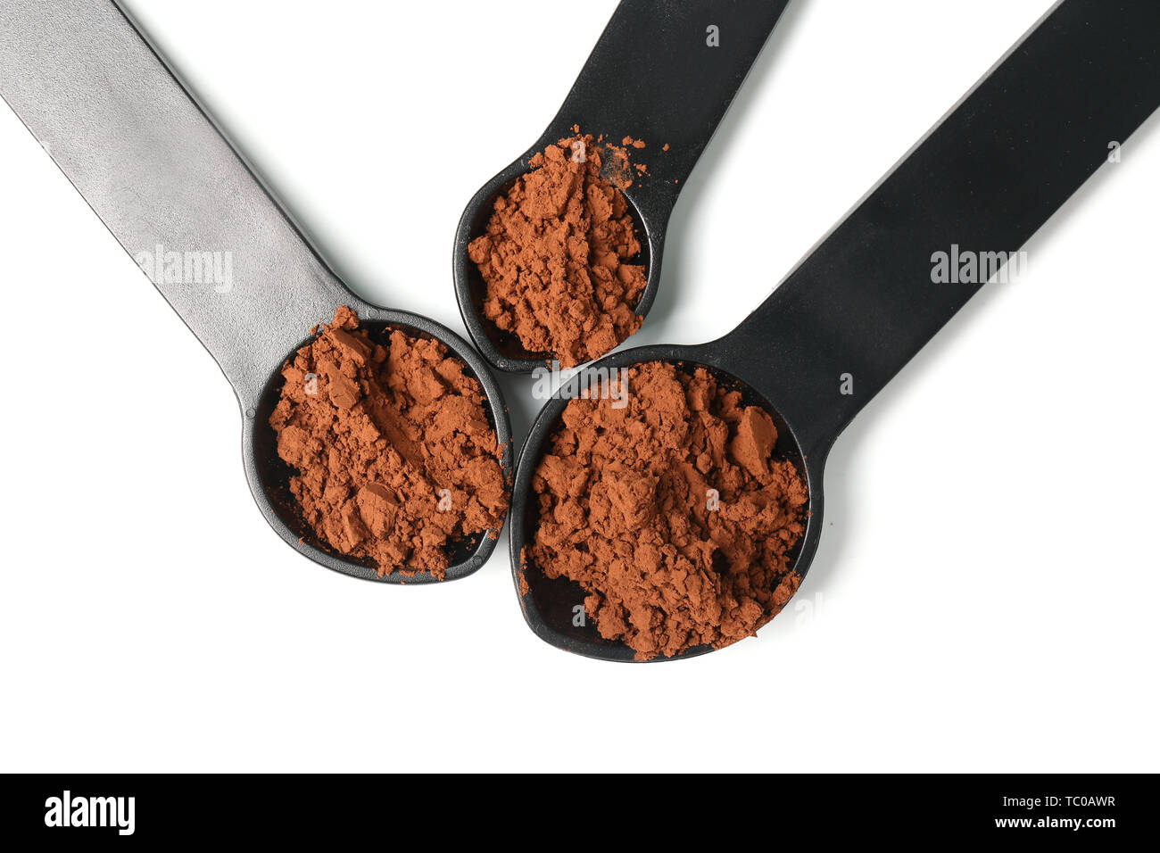 Spoons with cocoa powder on white background Stock Photo - Alamy