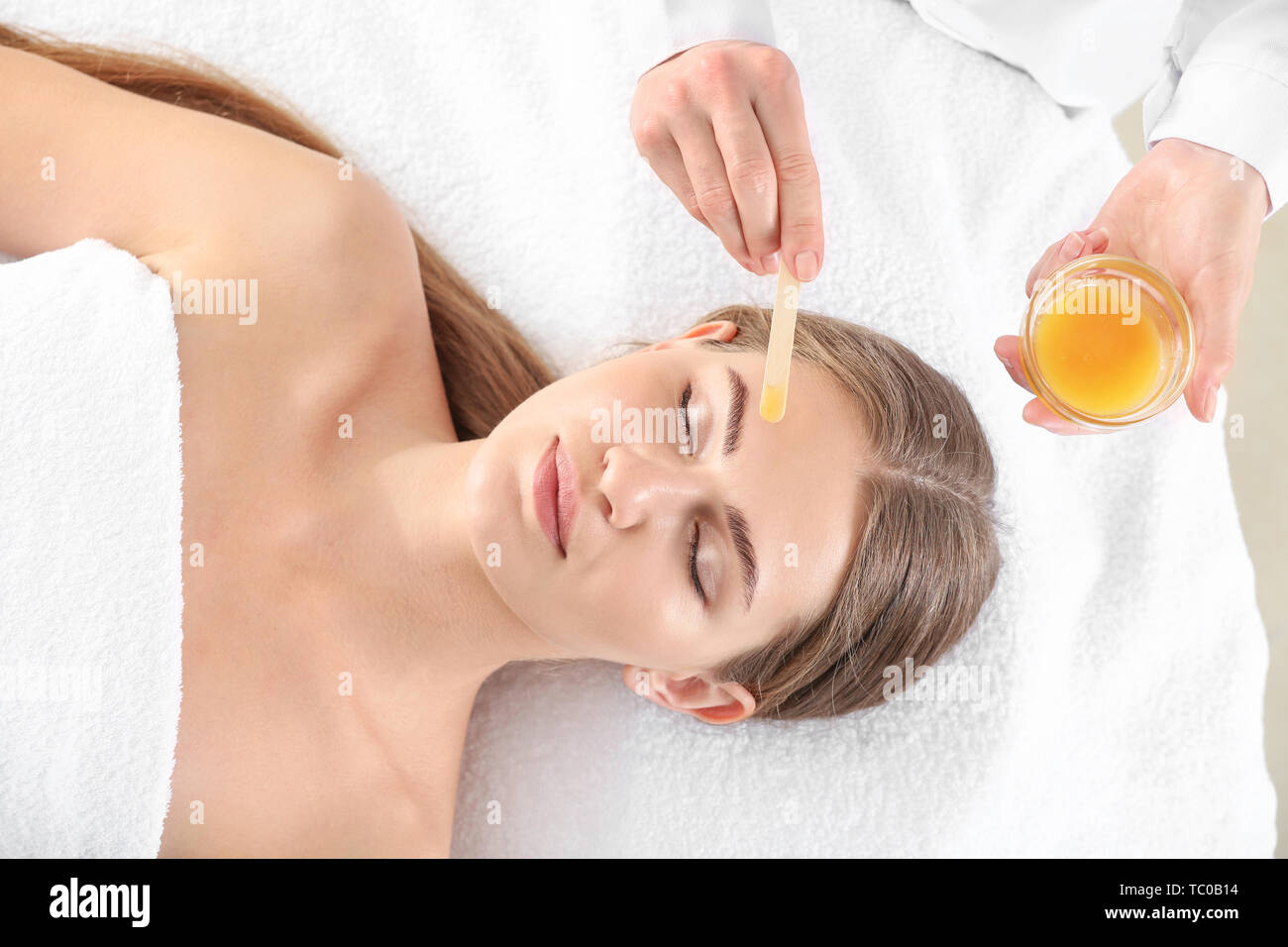 Young woman undergoing eyebrows epilation in beauty salon Stock Photo ...