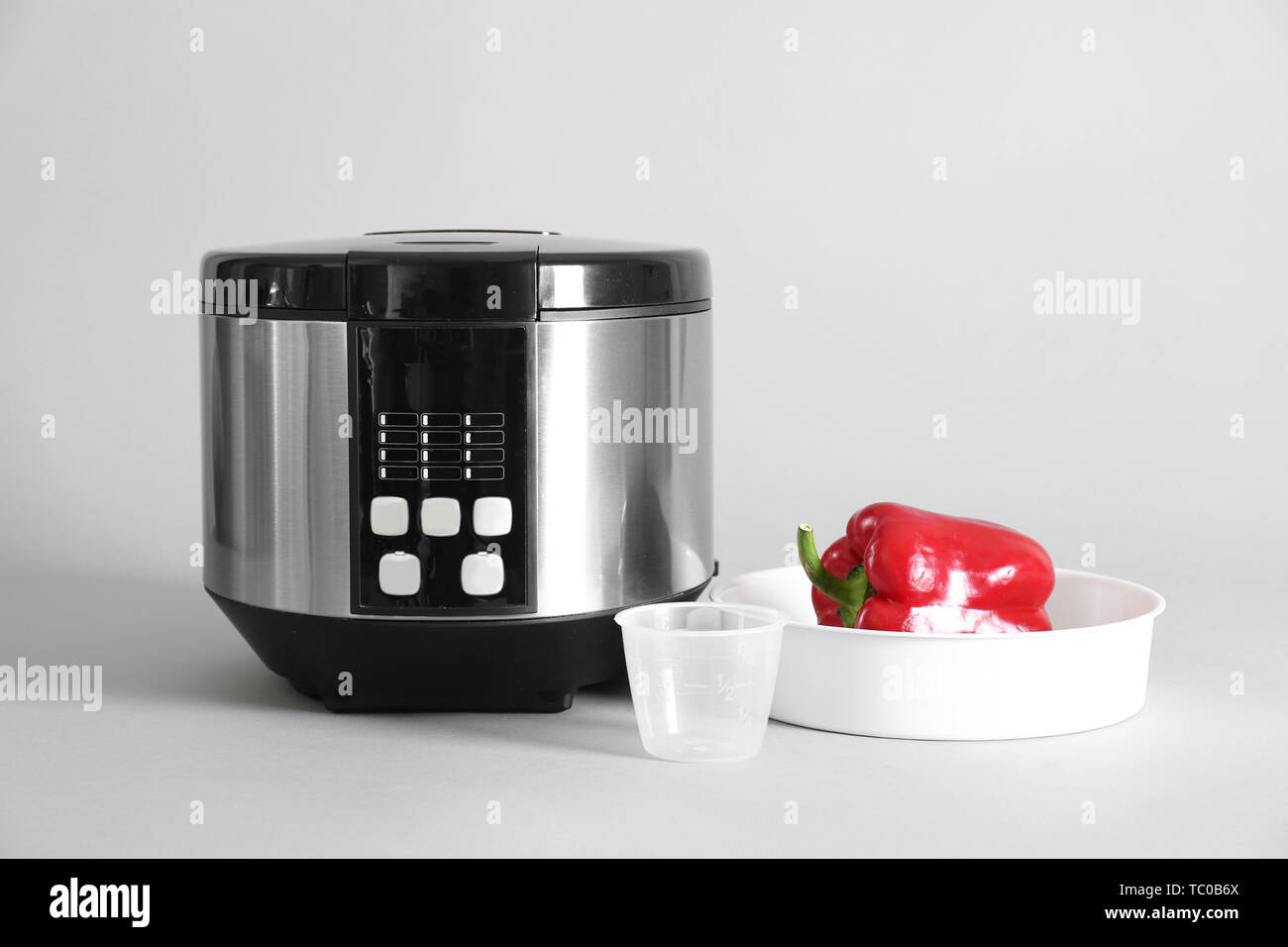Modern multi cooker and accessories on light background Stock Photo - Alamy