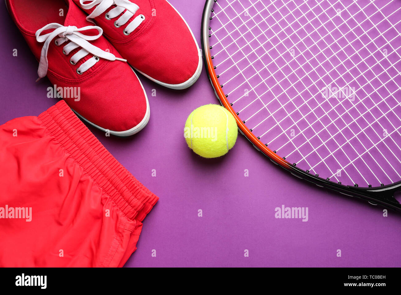 Tennis racket, shoes, clothes and ball on color background Stock Photo ...