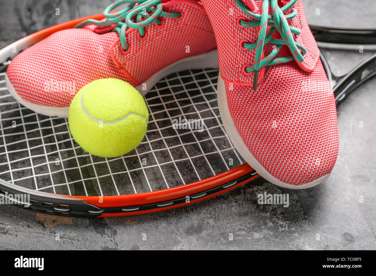 Tennis racket, shoes and ball on grey background, closeup Stock Photo ...
