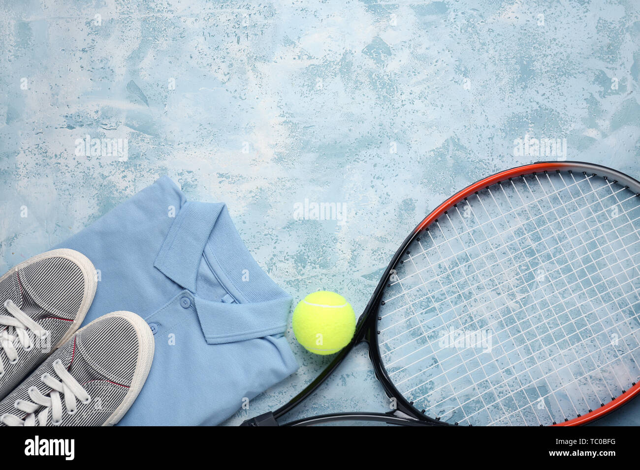 Tennis racket, shoes, clothes and ball on color background Stock Photo ...