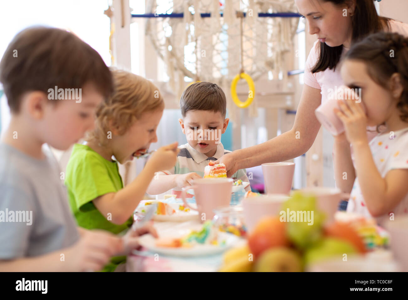 Kids eat festival cake at holiday in daycare Stock Photo - Alamy