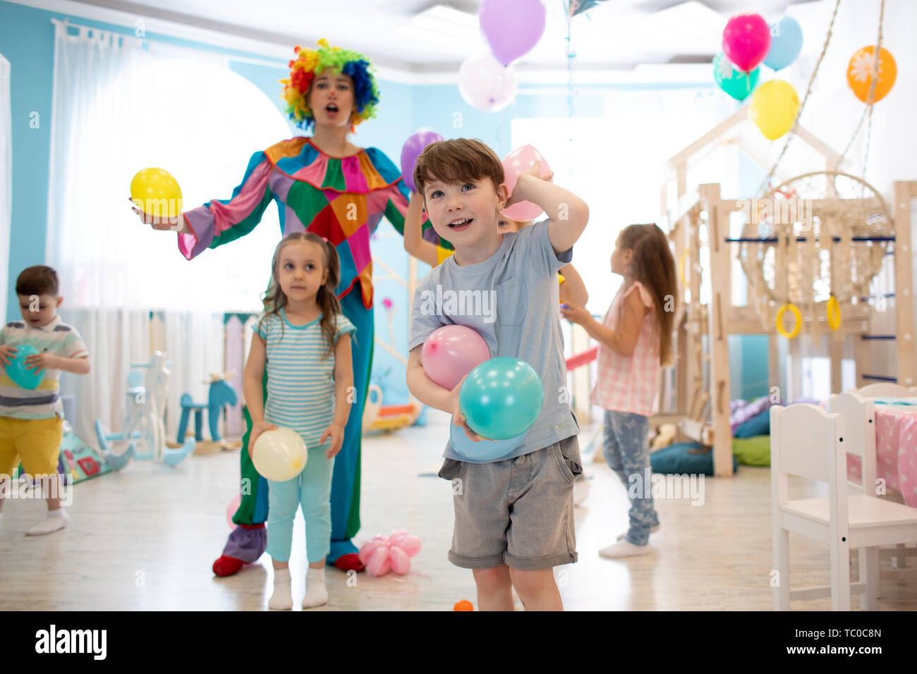 joyful childs and clown play with color balloon on birthday party Stock ...