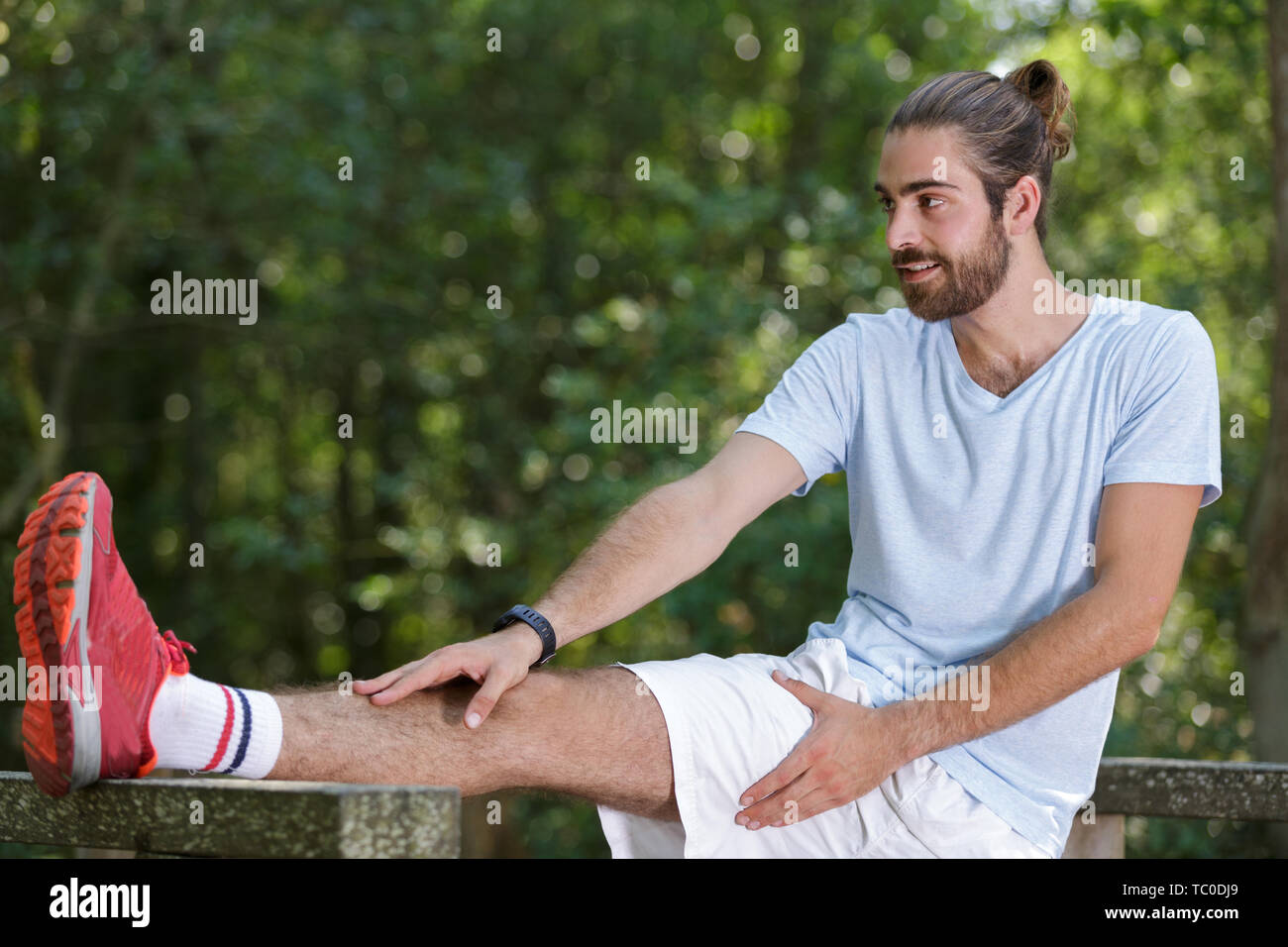 male runner stretching leg muscles on wooden fence Stock Photo - Alamy