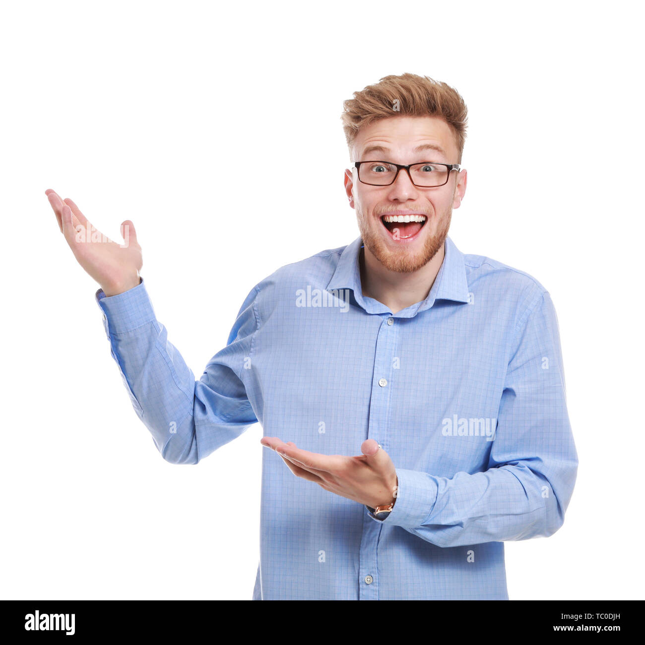 Portrait of happy young man pointing at something on white background ...