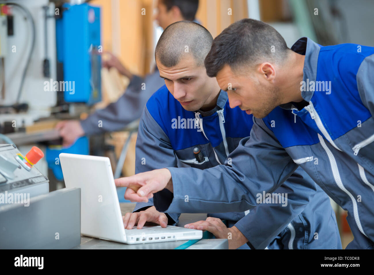 workers inspecting some information from the laptop Stock Photo - Alamy