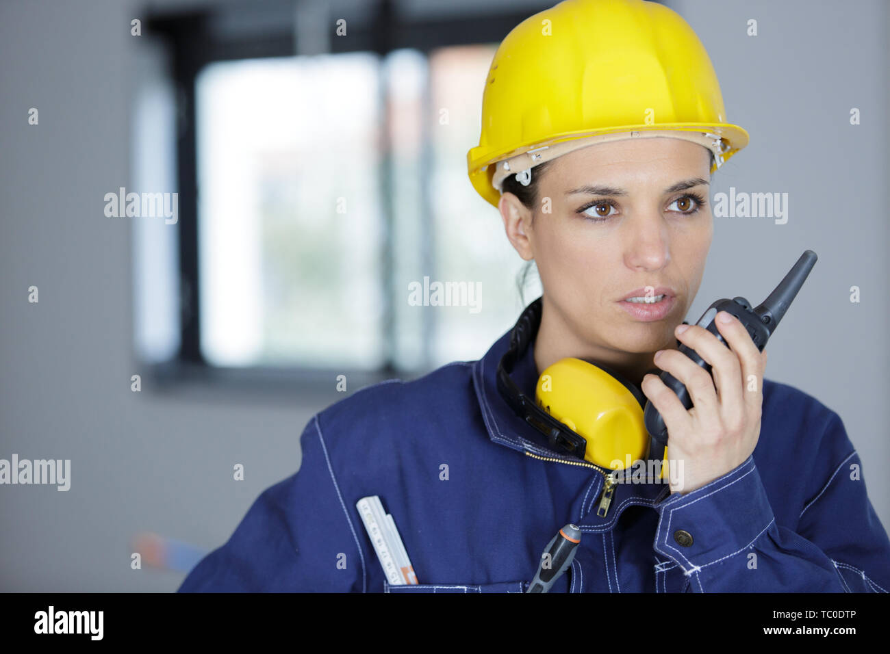 female inspector with walkie talkie in site Stock Photo - Alamy