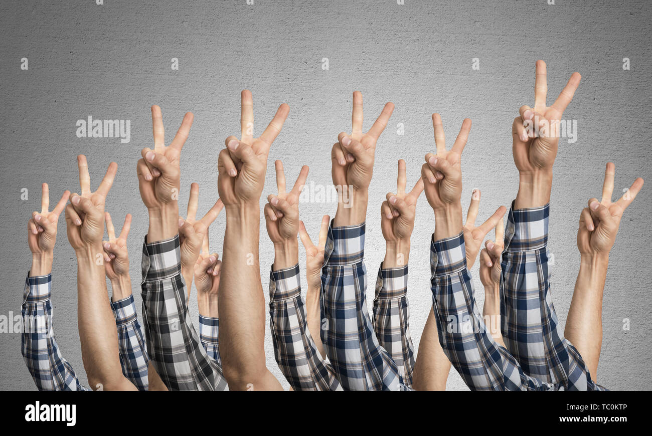 Row of man hands showing victory gesture Stock Photo - Alamy
