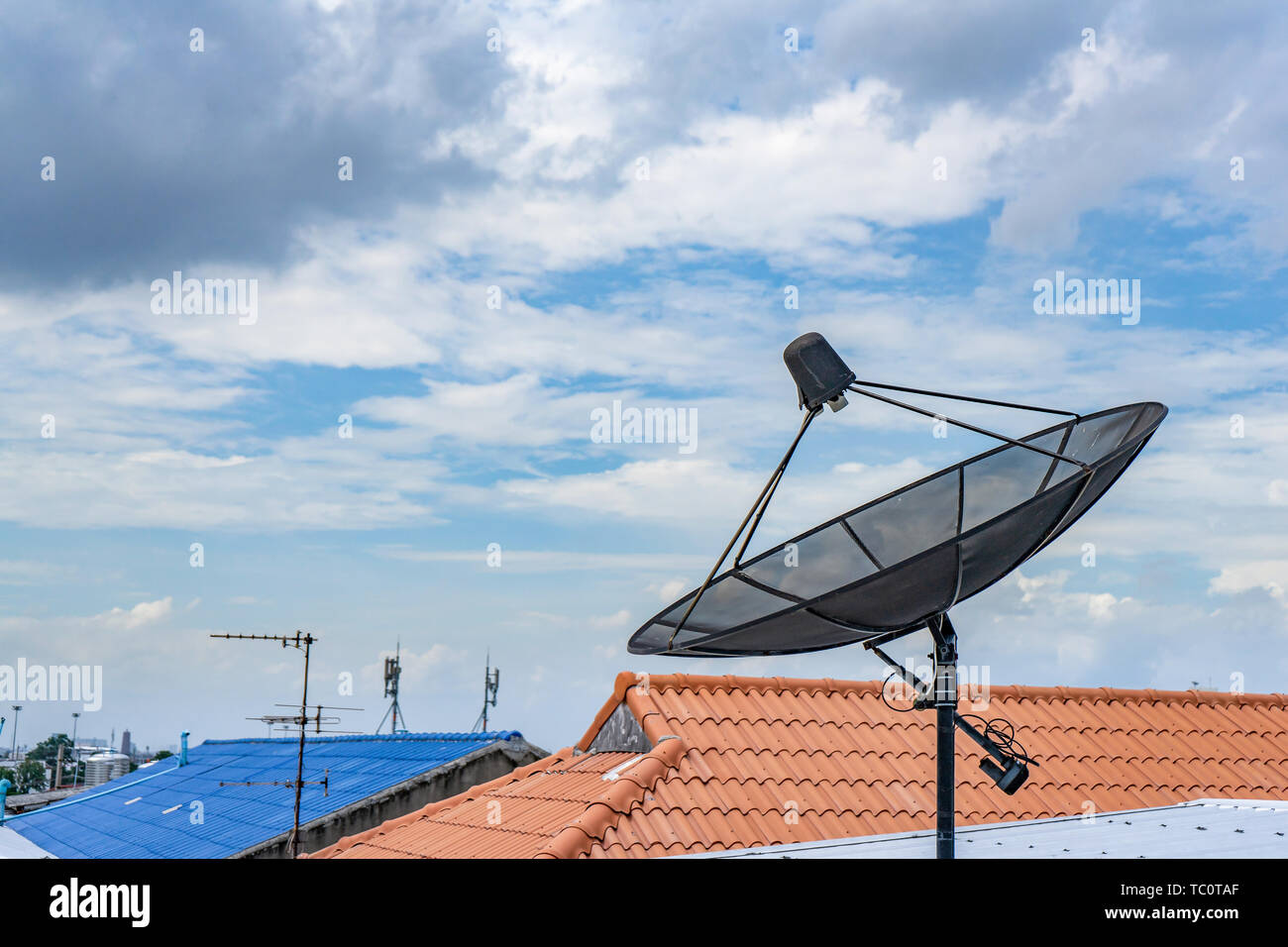 Digital TV Satellite receiver on the roof top with cloudy in the sky ...