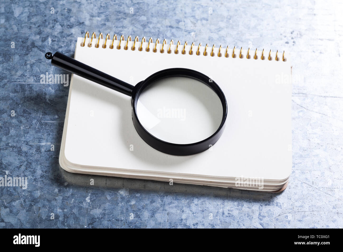 Notebook and magnifier Stock Photo - Alamy
