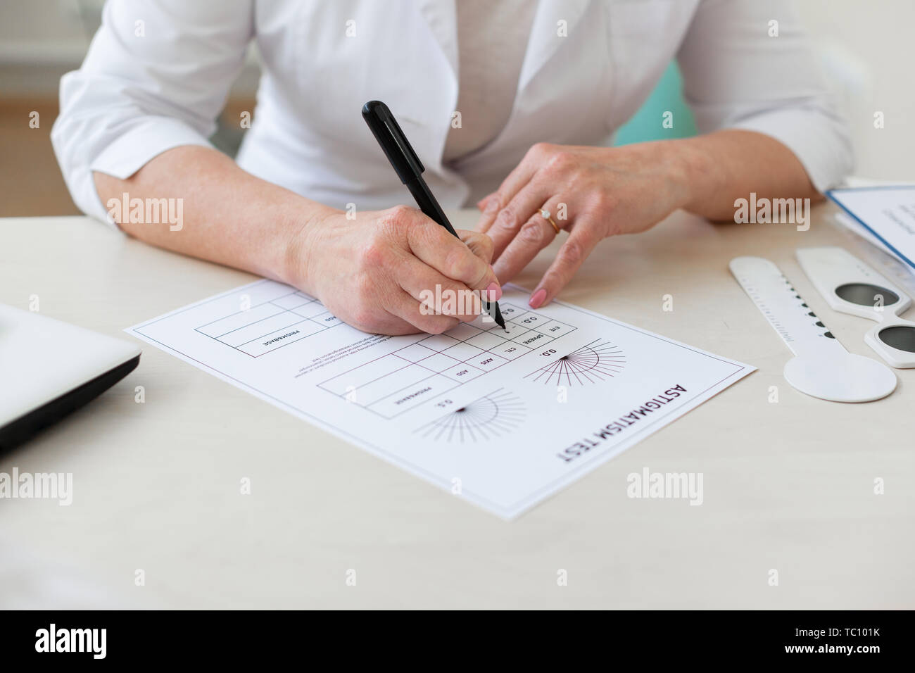 Pleasant kind doctor. Focused ophthalmologist writing down results of ...