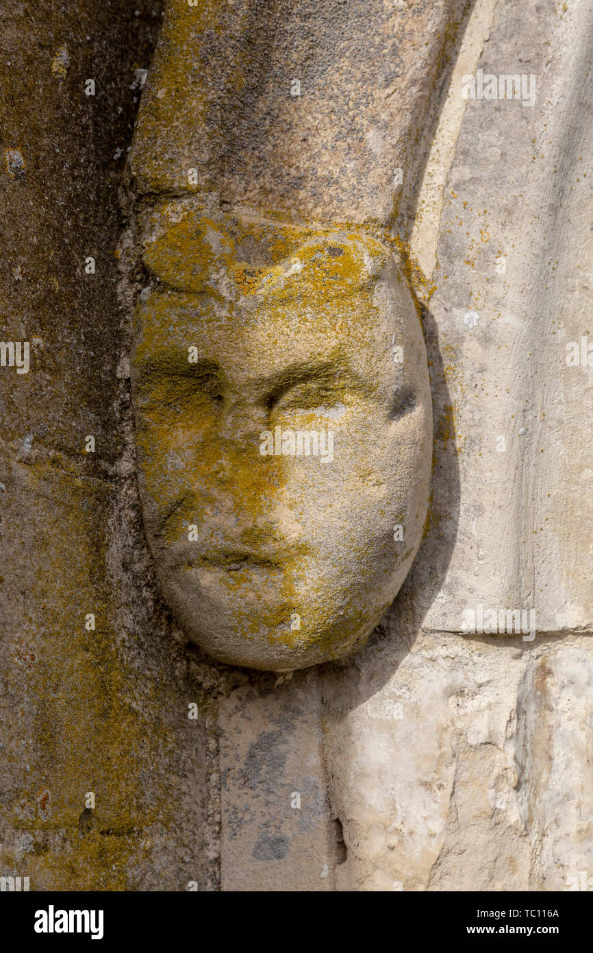 Ancient cared stone face in exterior wall, Holy Trinity Church, Long ...